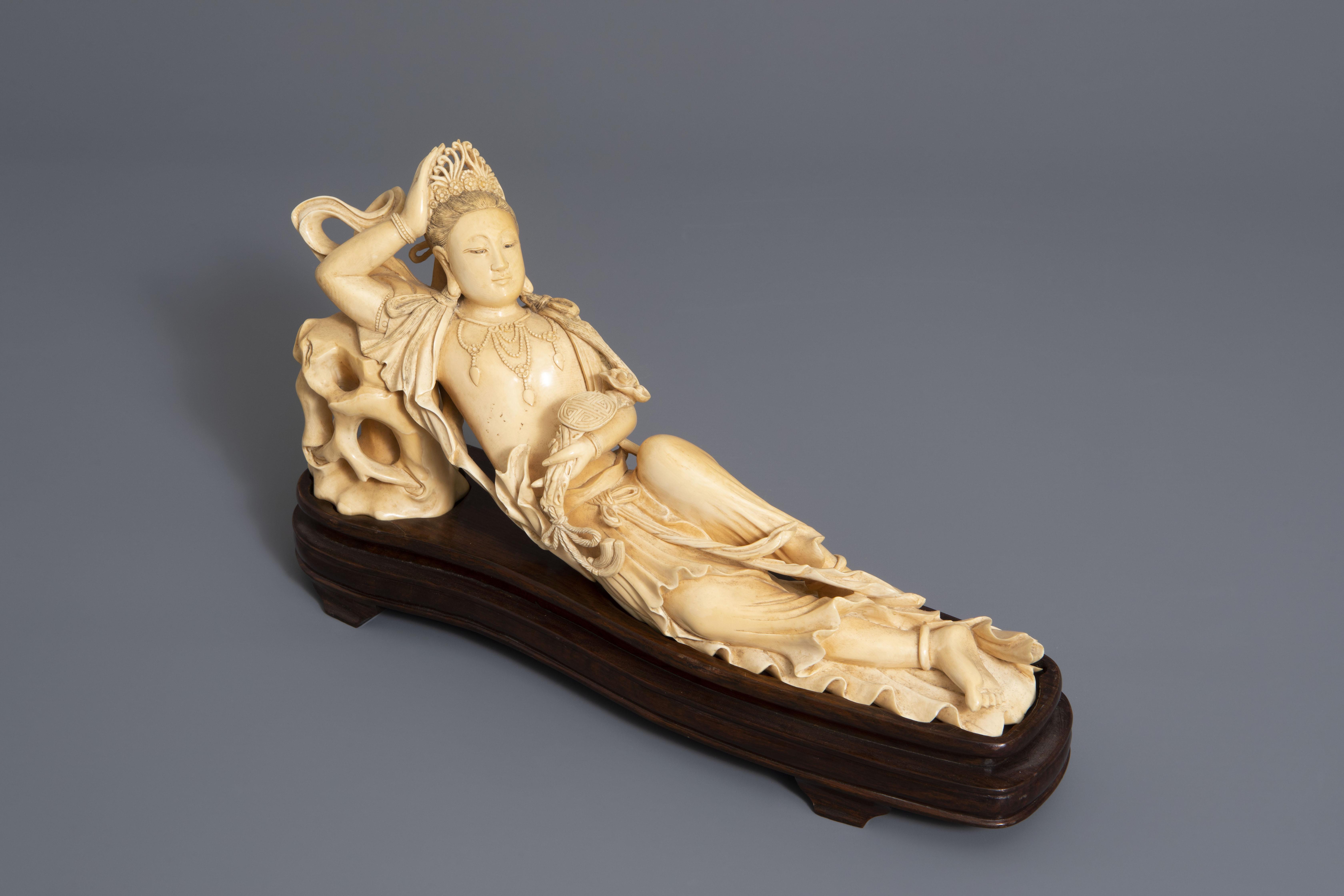 A large Chinese ivory model of a reclining lady on wooden stand, late ...