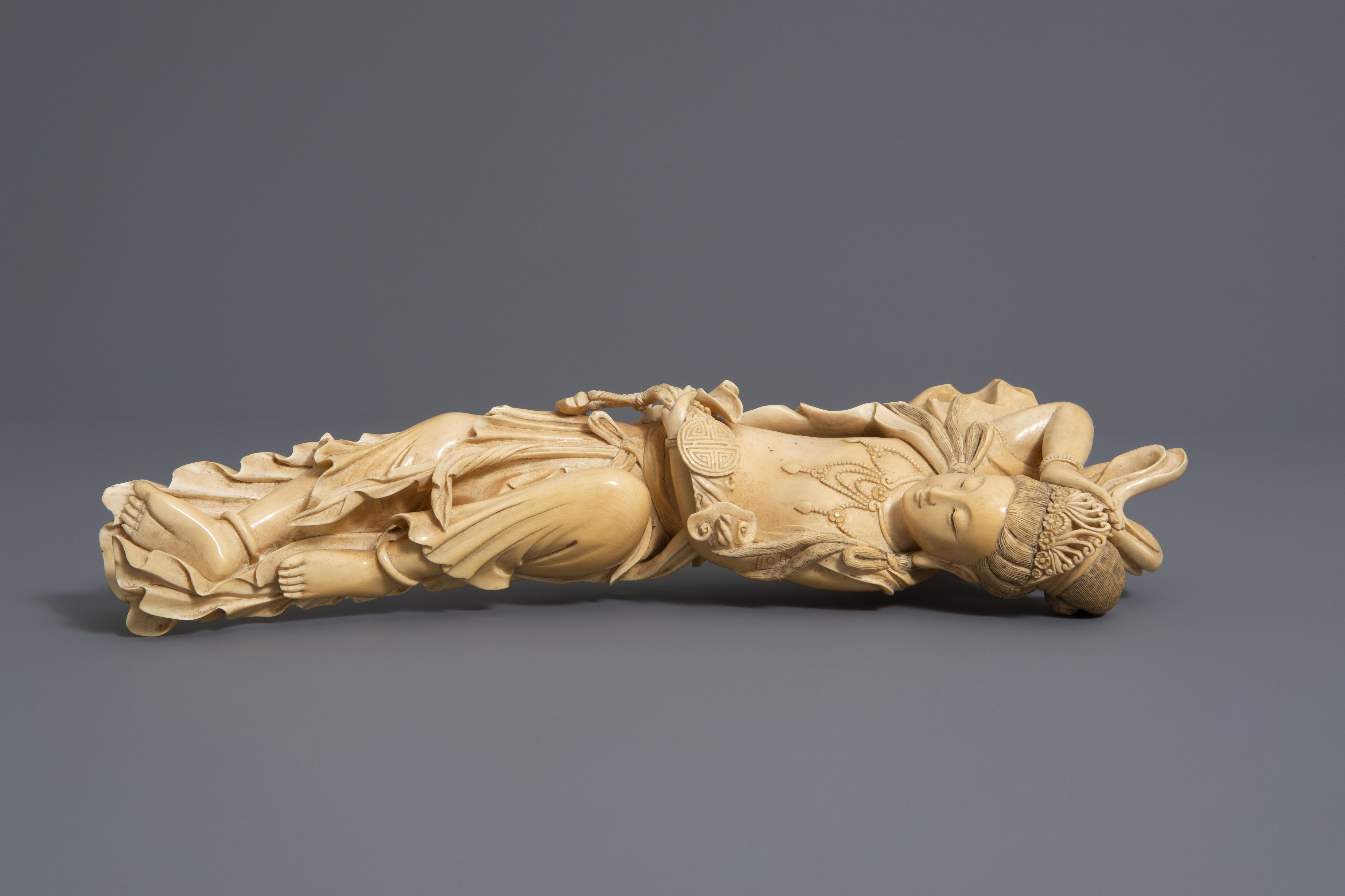 A large Chinese ivory model of a reclining lady on wooden stand, late ...