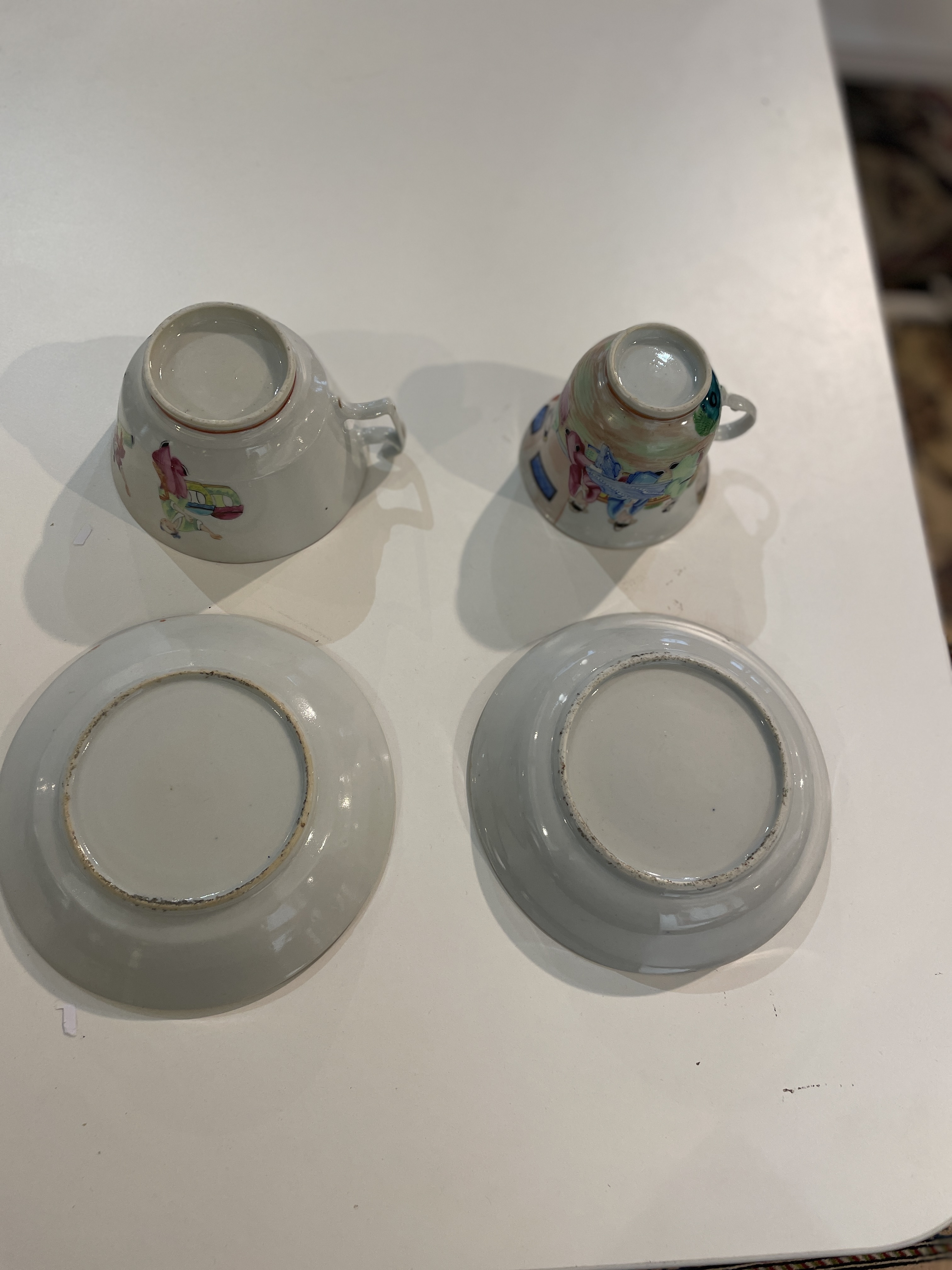 Two Chinese Canton famille rose cups and saucers with animated scenes ...